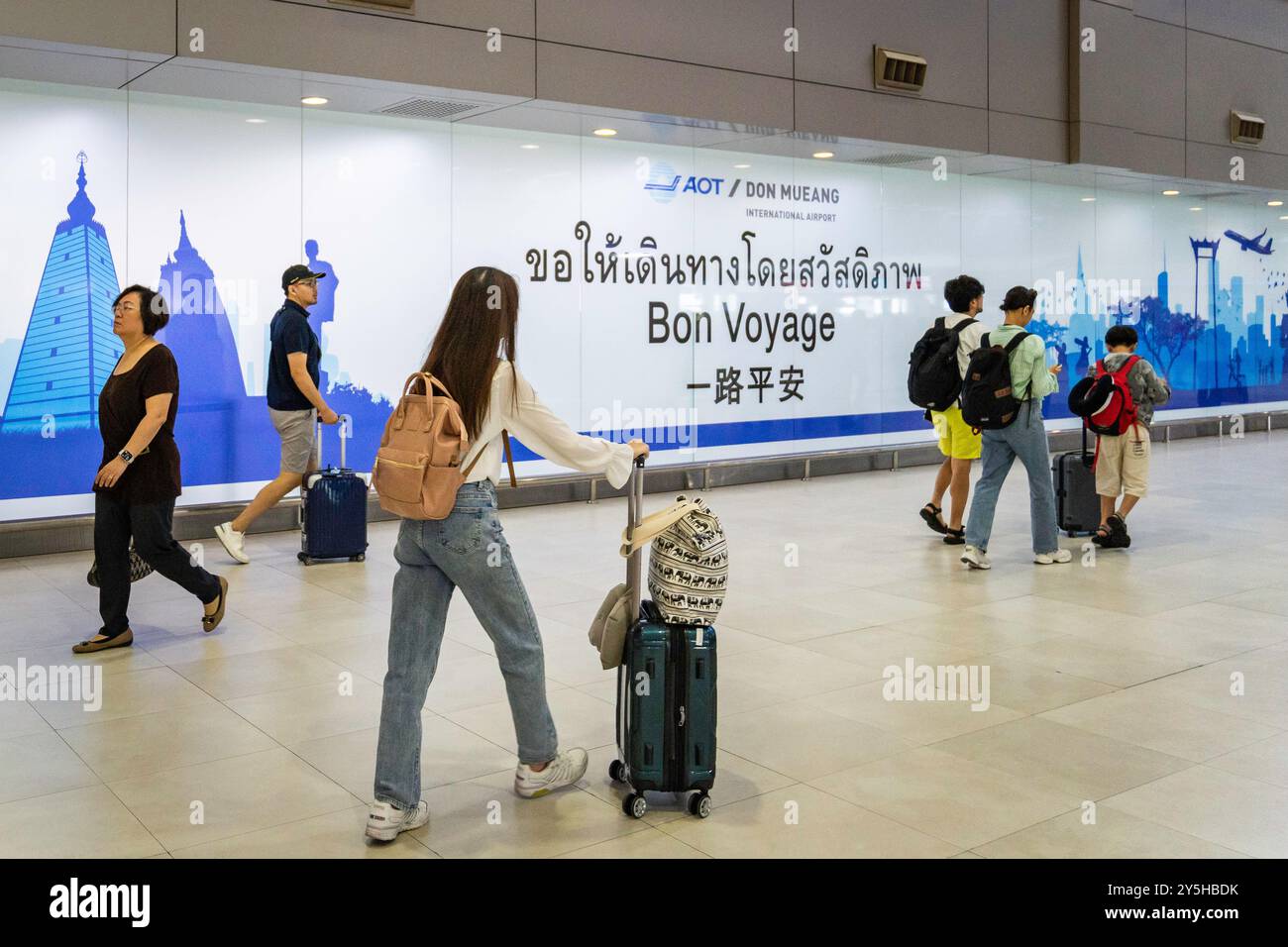 Passengers are seen walking with their luggage, in a departure zone, at ...