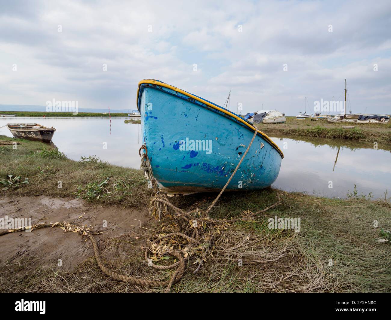 Heswall, Dee estuary. Blue boat is tied to a dock. The boat is dirty ...
