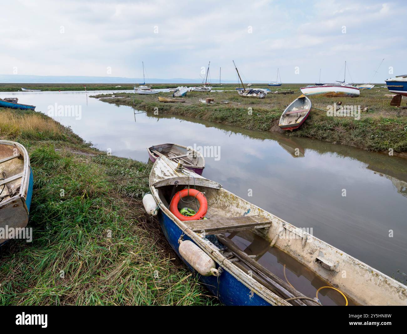 Heswall, Dee estuary. Row of boats are sitting in a muddy river. The ...