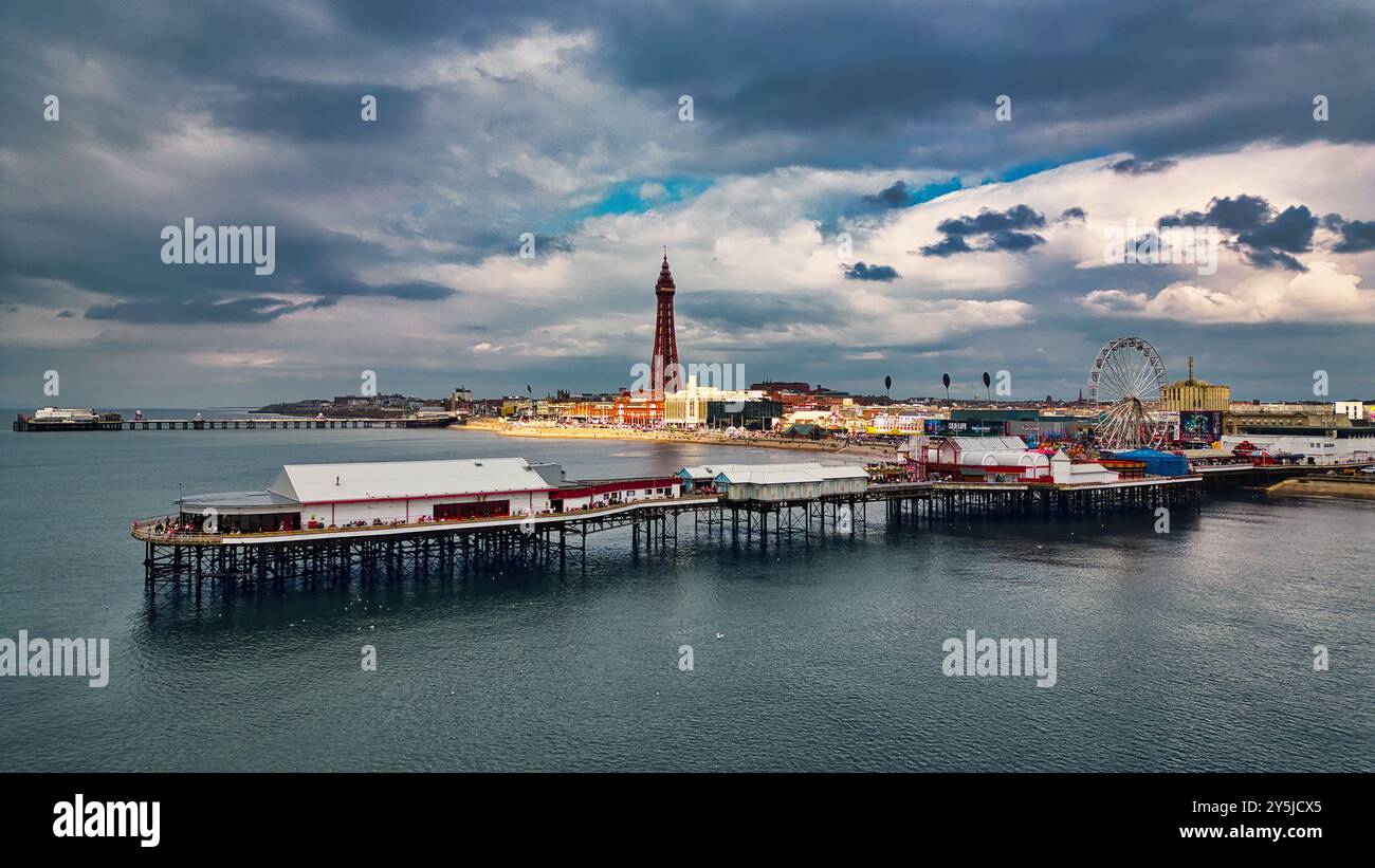 A scenic view of a seaside pier with amusement rides, a tall tower, and ...