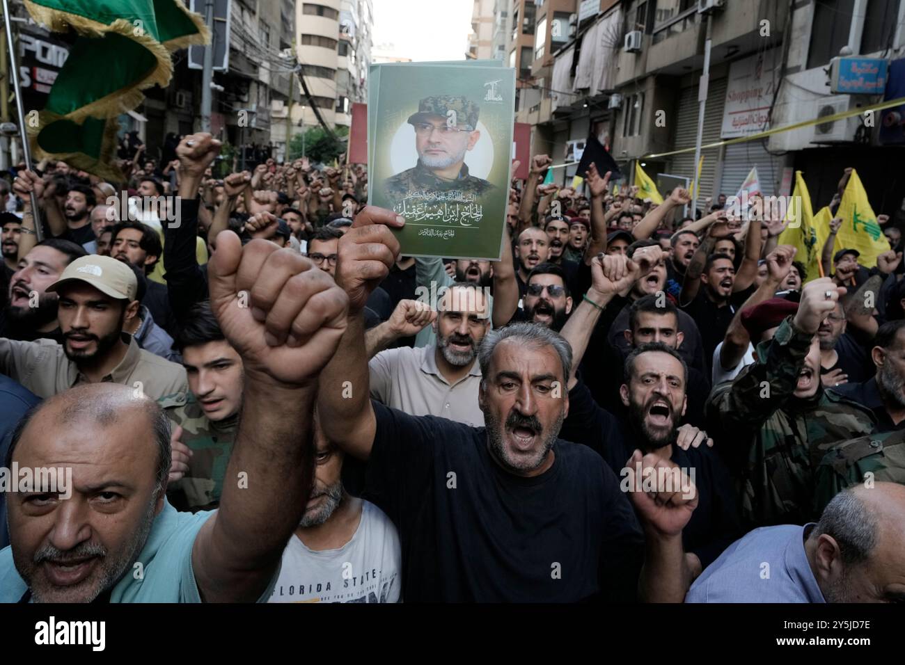 Hezbollah supporters carry pictures of Hezbollah commander Ibrahim Akil, during his funeral ...