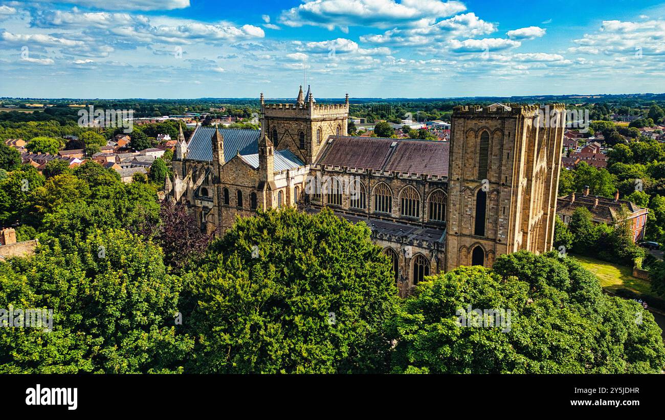 Aerial view of a historic cathedral surrounded by lush greenery and a ...