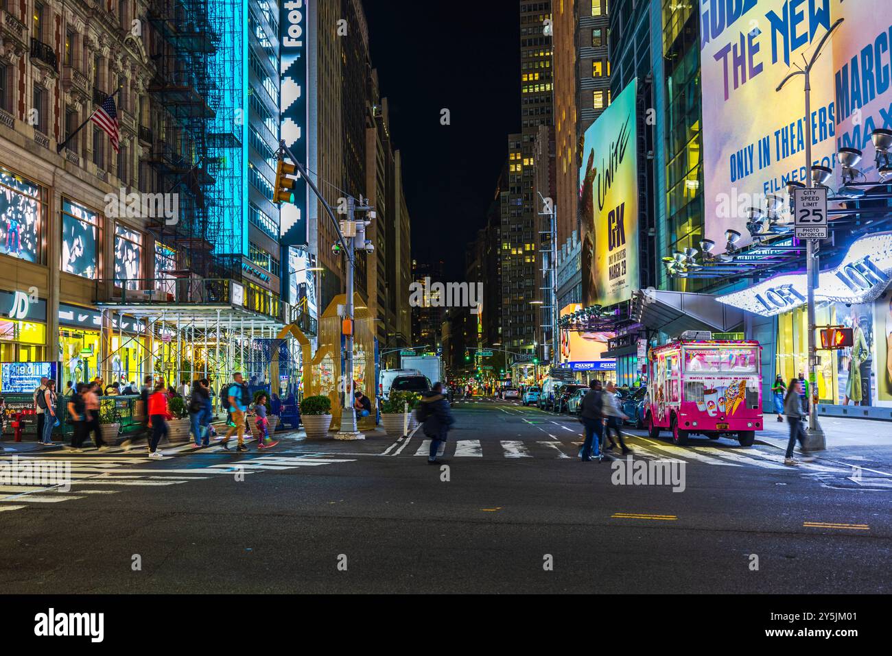 Nighttime view of a busy street in Times Square with pedestrians ...