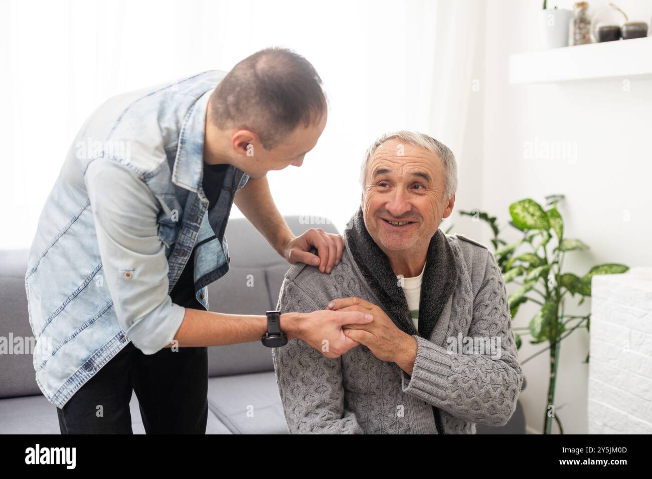 Elderly son takes care of ill father Stock Photo - Alamy