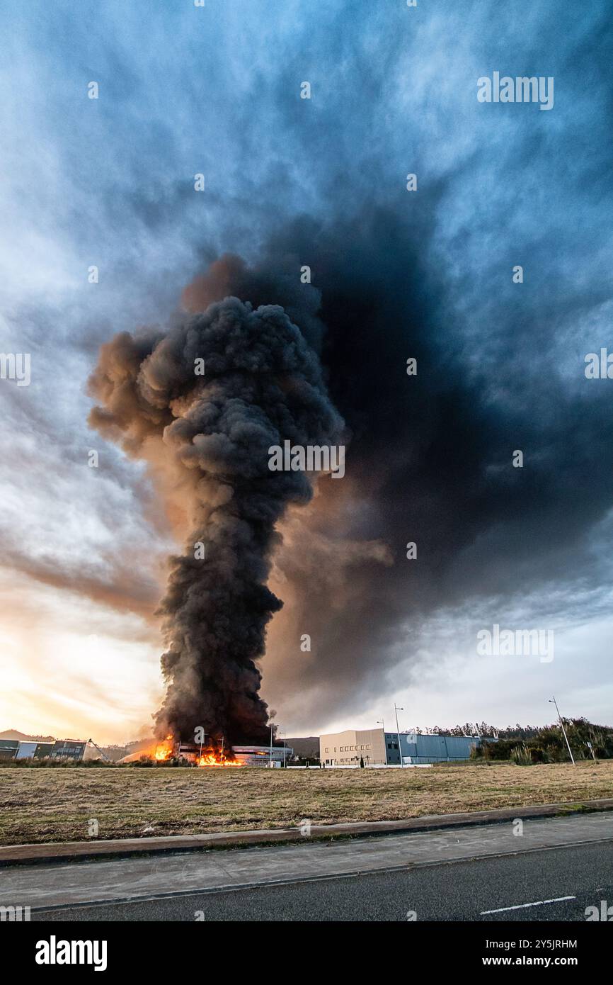 A big column of smoke rises for a fire in an industrial estate Stock ...
