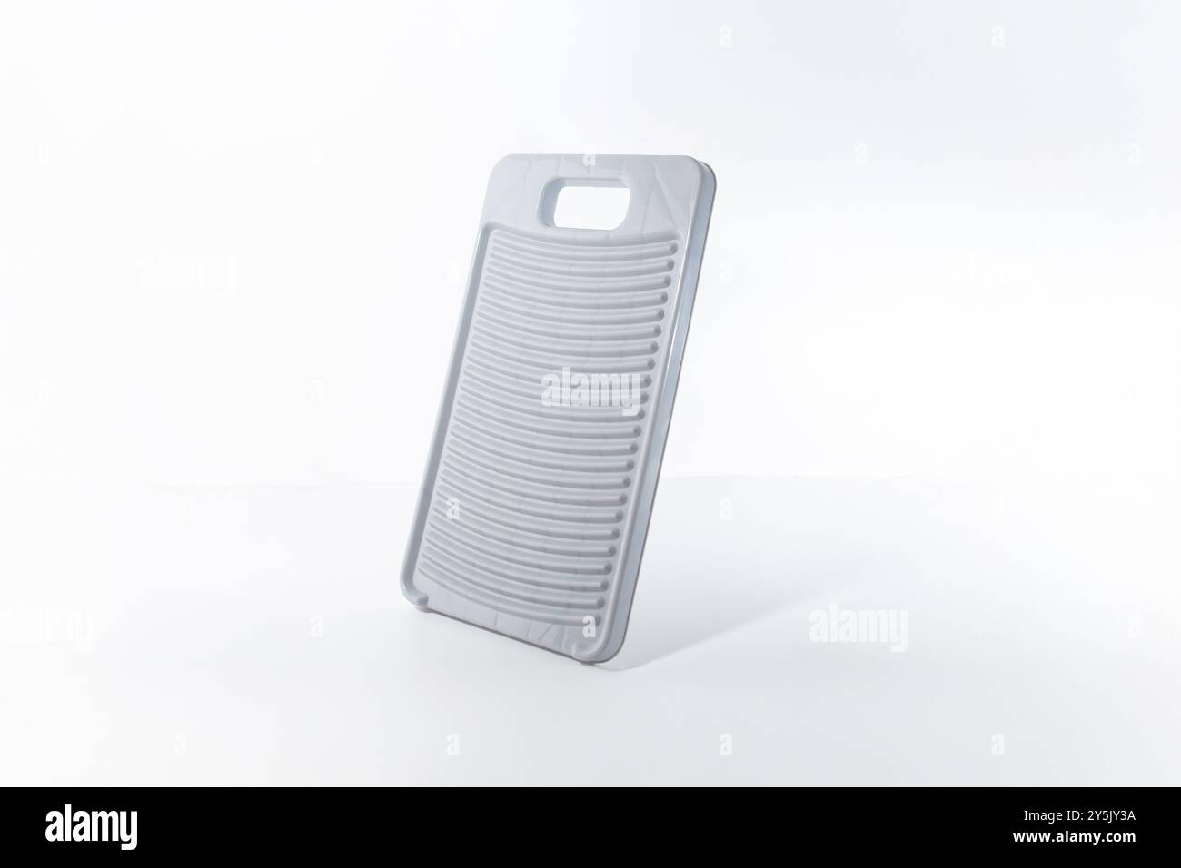 Light gray washboard, plastic material, upright on flat surface, white ...