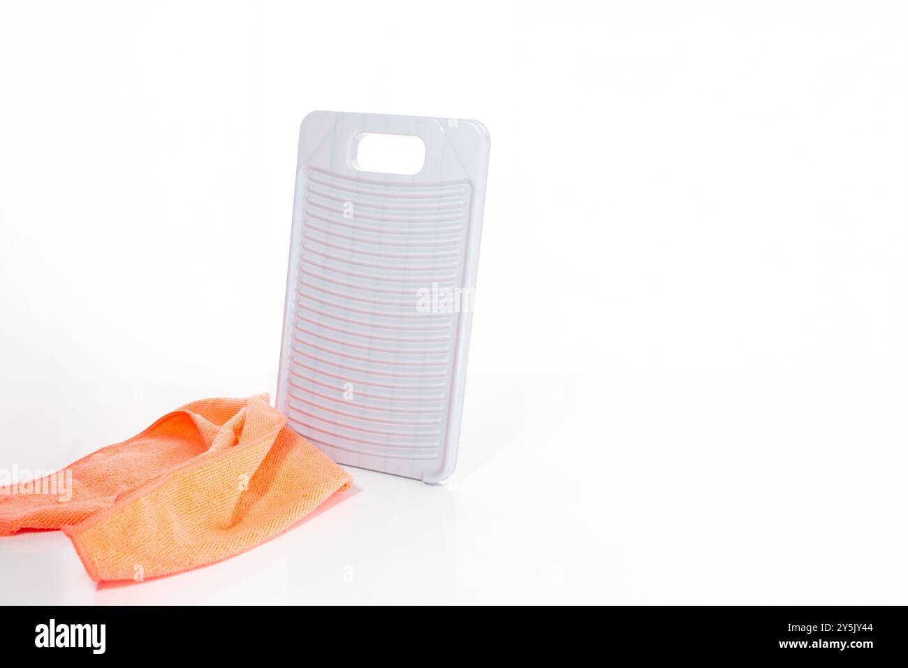 Gray plastic washboard with handle, horizontal ridges, orange cloth ...