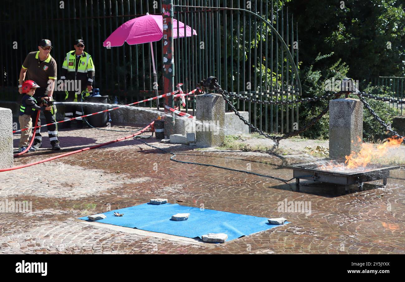 Volunteer fireman teaching a child how to put out a fire Stock Photo ...