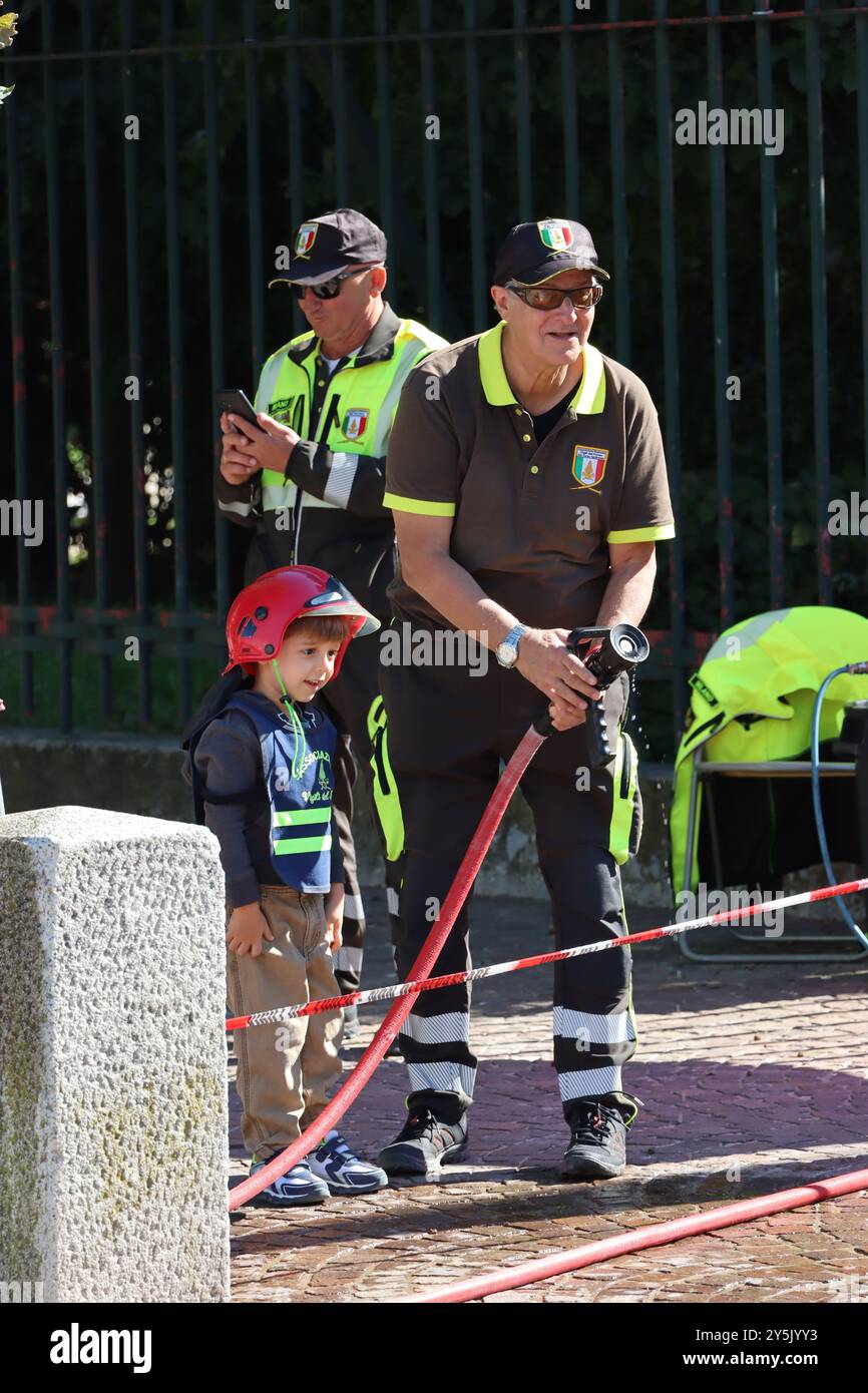 Volunteer fireman teaching a child how to put out a fire Stock Photo ...