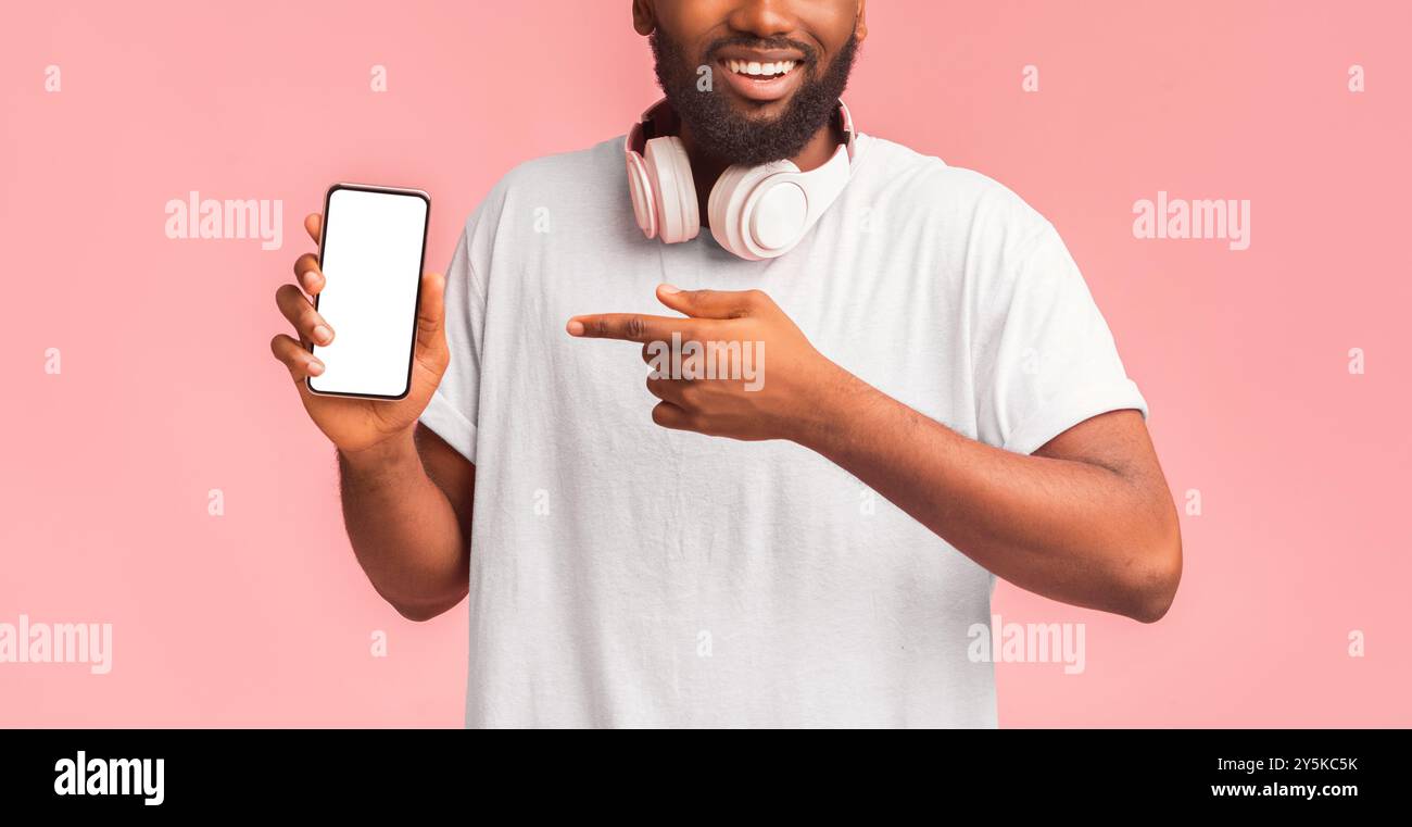 Afro guy pointing at blank smartphone screen Stock Photo - Alamy