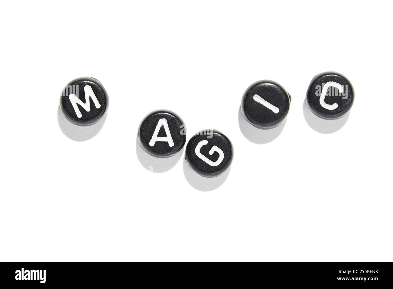 Black beads with white letters spelling magic on white background for ...