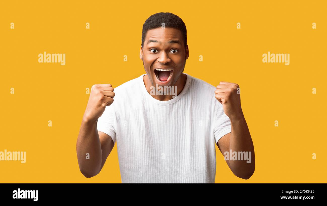 Afro man shouting over orange studio background Stock Photo - Alamy