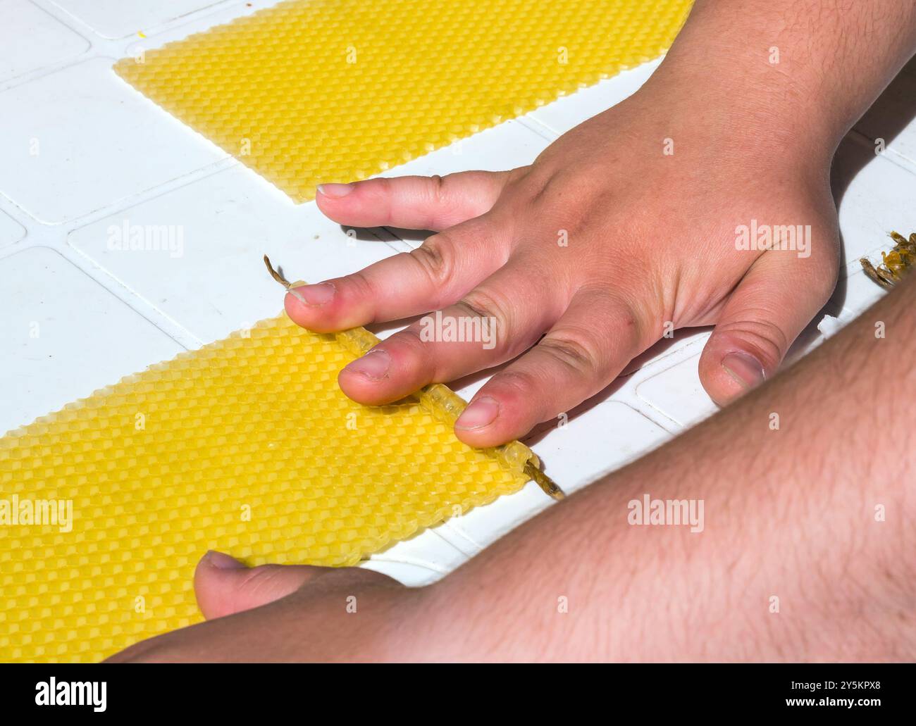 The process of rolling a candle from a sheet of foundation Stock Photo ...