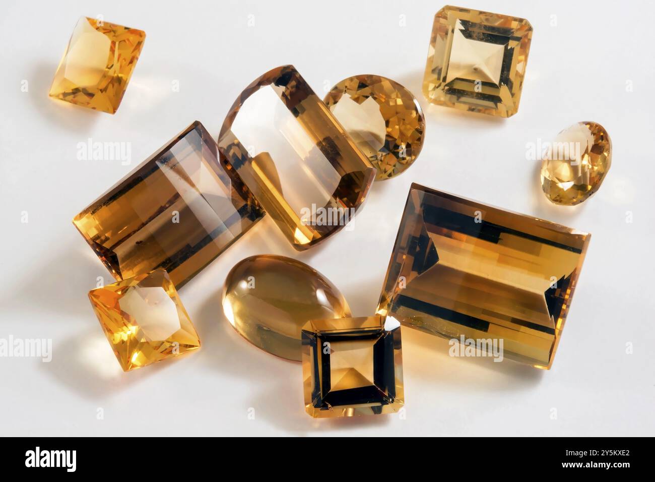 Several yellow citrine stones with different types of cutting in white ...