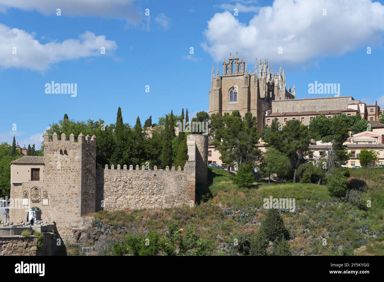 Medieval cityscape with church, city walls and trees under a blue sky ...