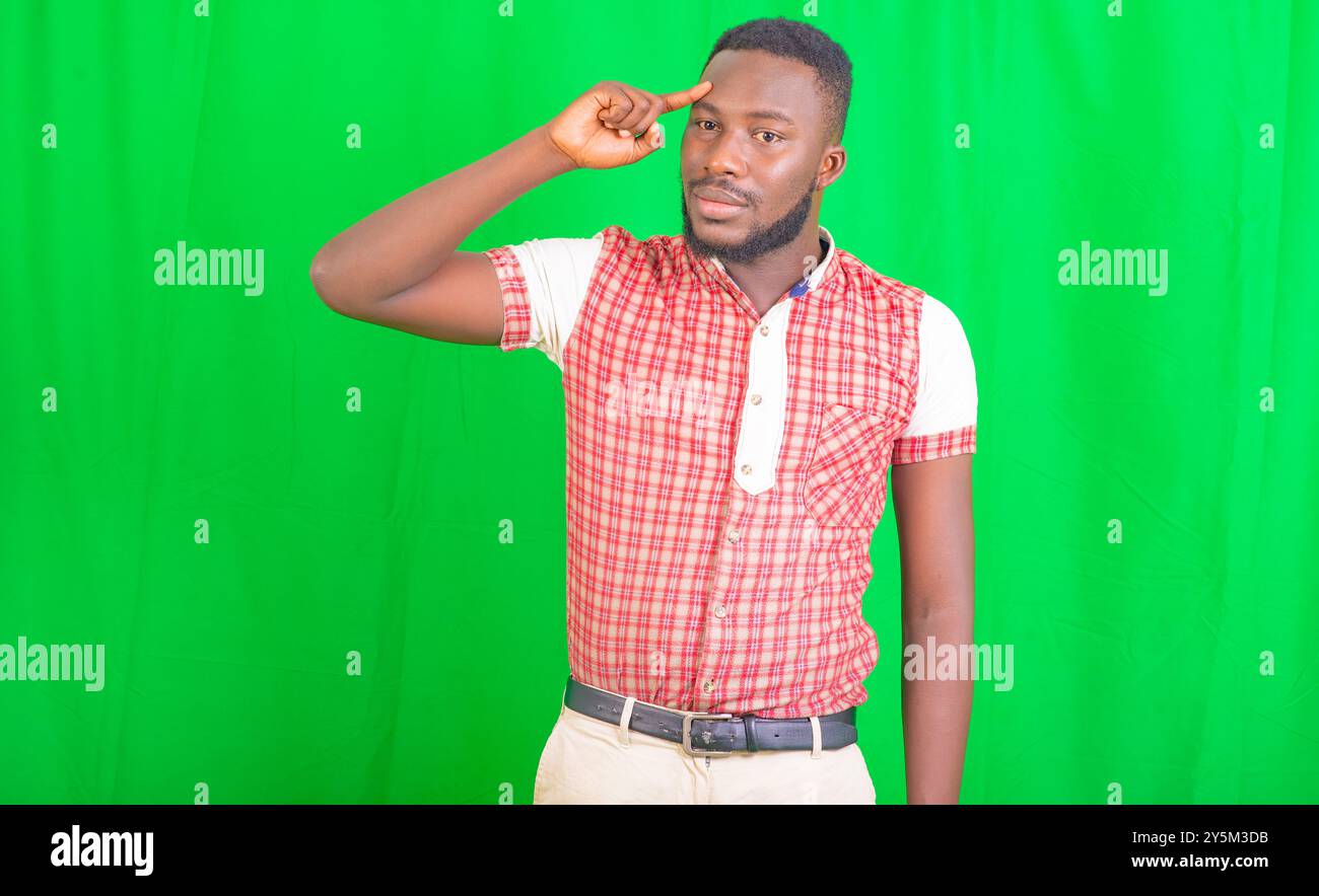 portrait of a handsome young man standing against green background ...