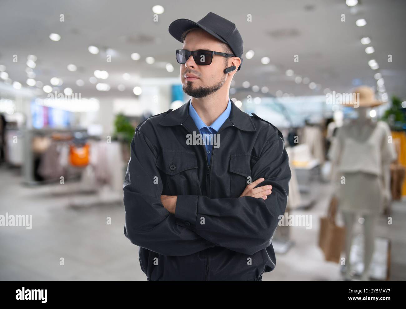 Confident security guard with earpiece in clothing store Stock Photo ...