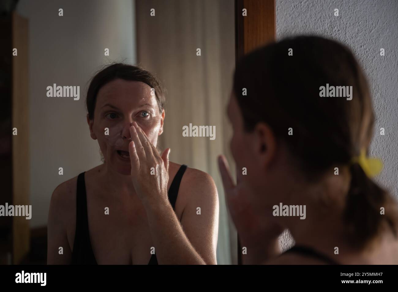 Woman applying sun lotion on face at home, selective focus Stock Photo ...