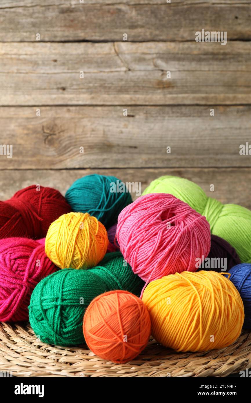 Pile of different yarns on wicker mat, closeup. Space for text Stock ...