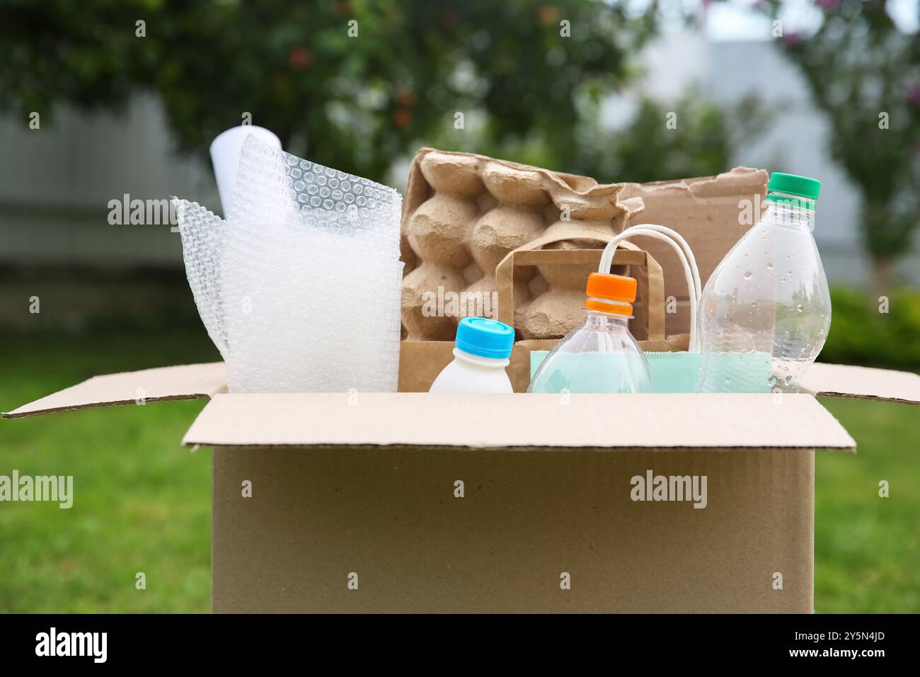 Recycling. Different garbage in cardboard box outdoors Stock Photo - Alamy