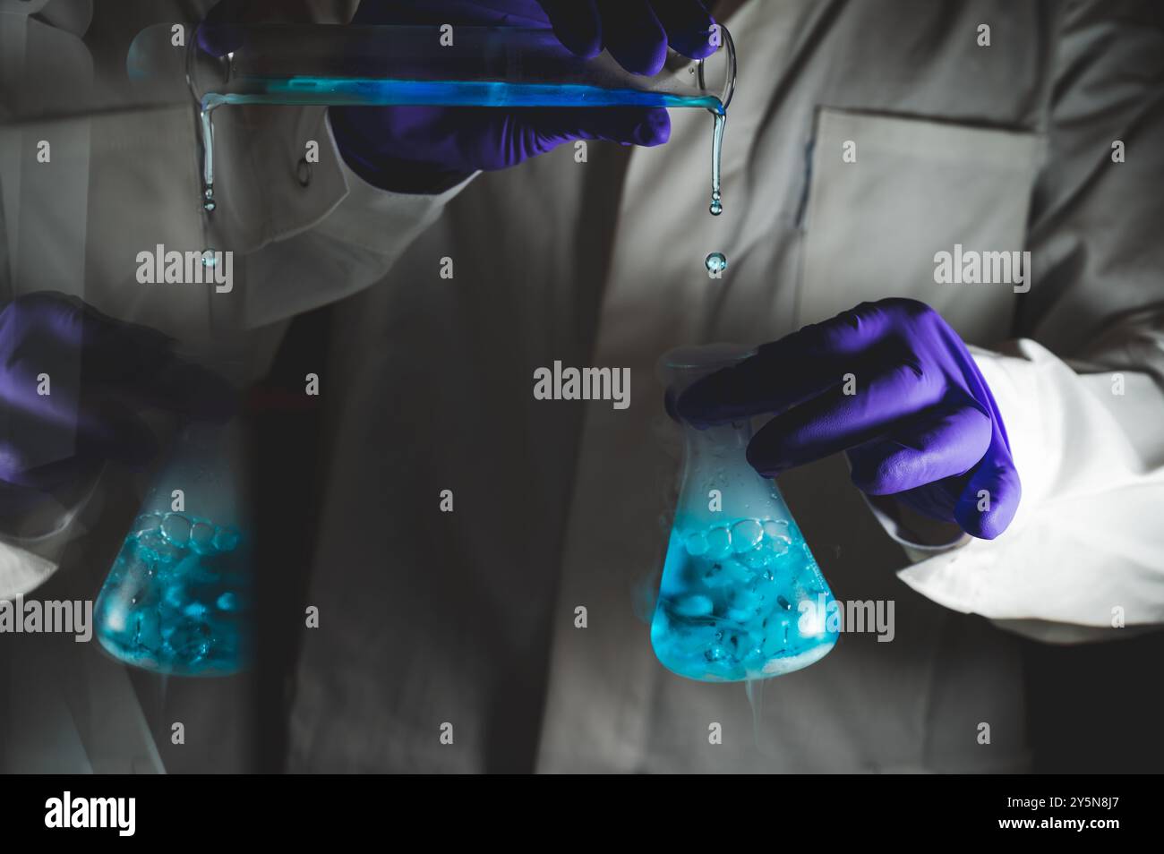 Smoky experiments with blue droplets. Scientist working on chemical reaction, generating thick ...