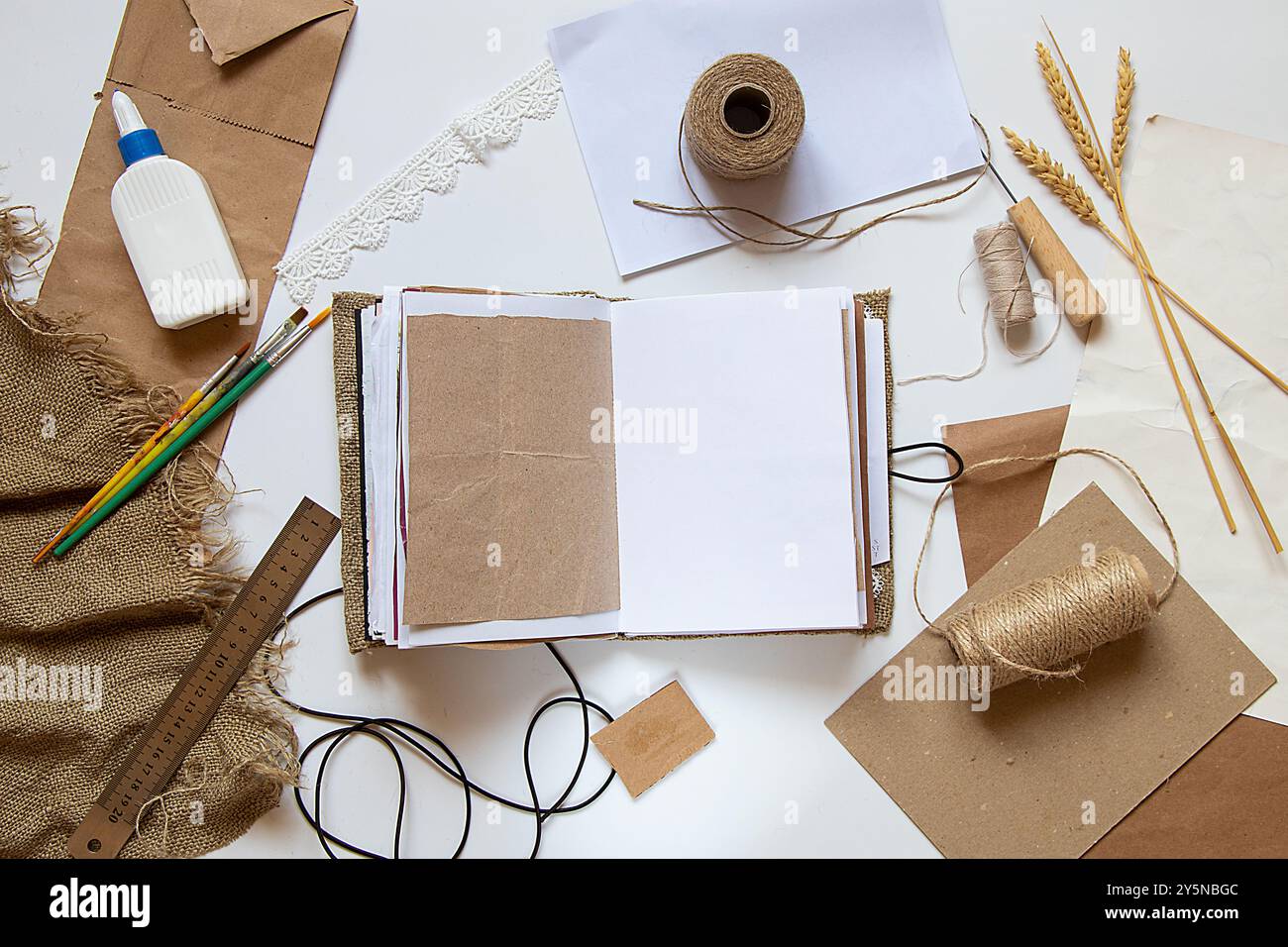 A homemade notebook lies on the table and next to it lie papers, glue ...
