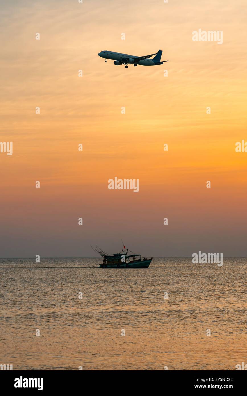 Passenger plane is landing over the sea and a floating fishing ship ...