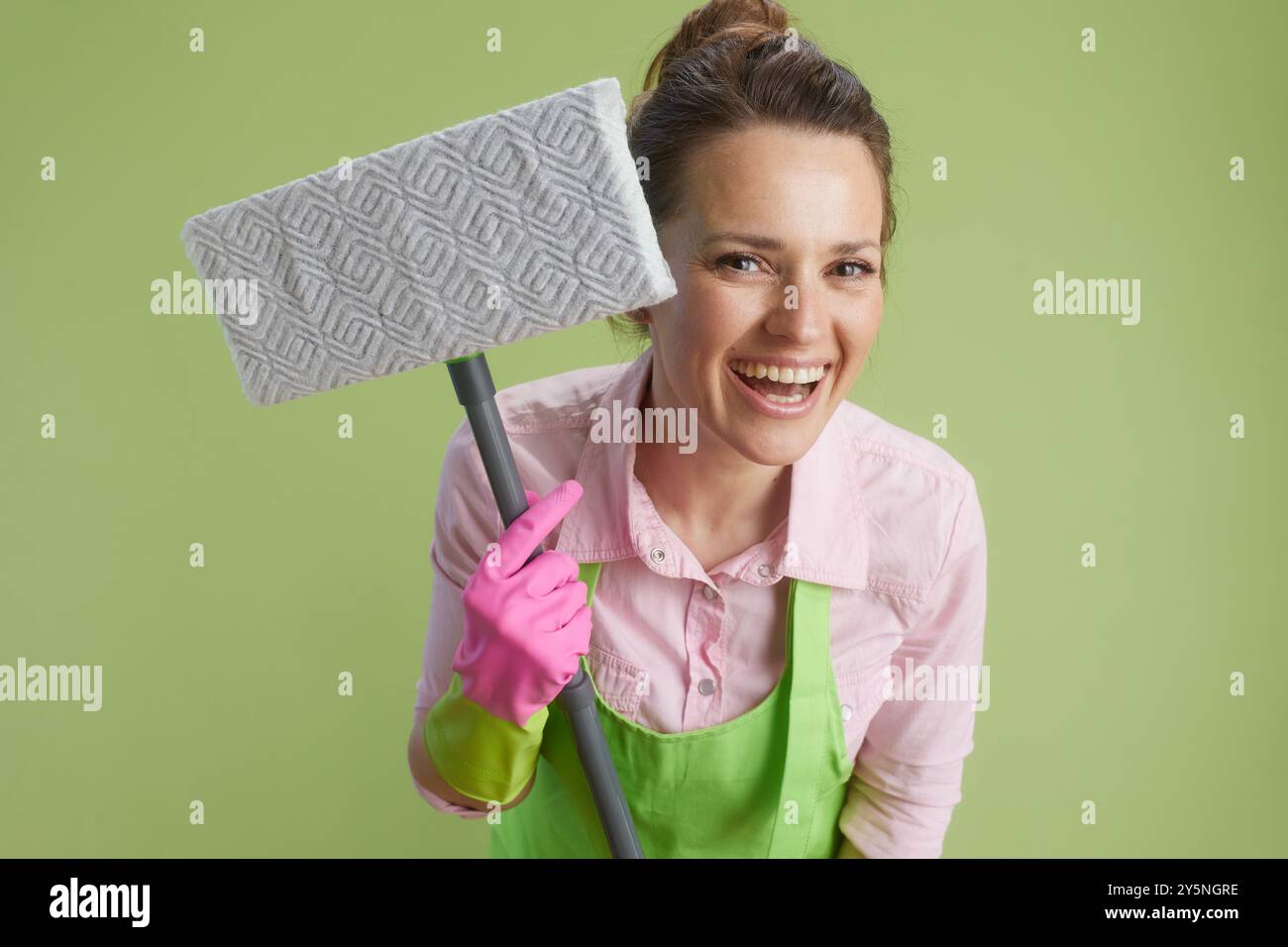 Spring cleaning. happy modern woman in green apron and rubber gloves ...