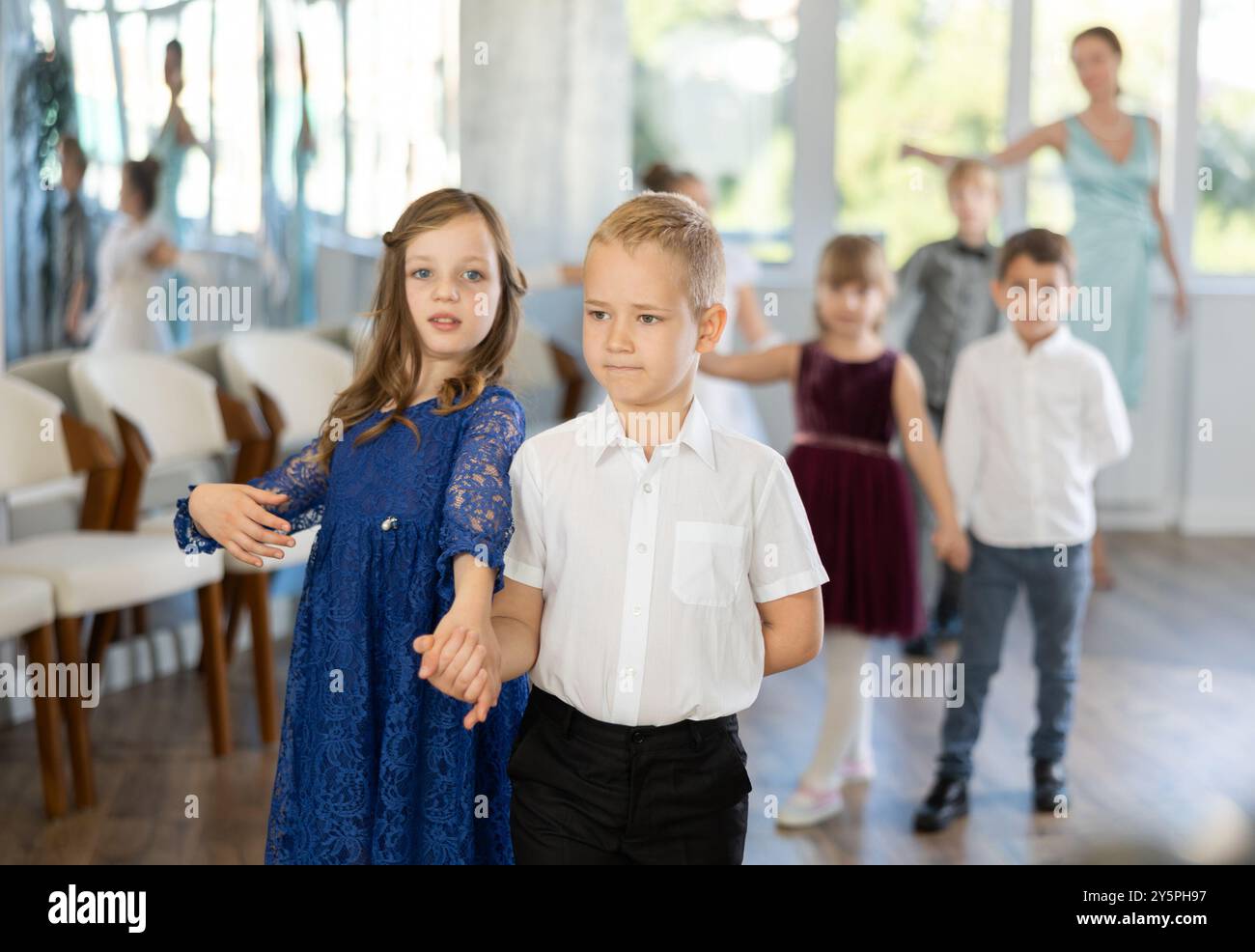 Little children in elegant dresses standing in pairs in dance pose in ...