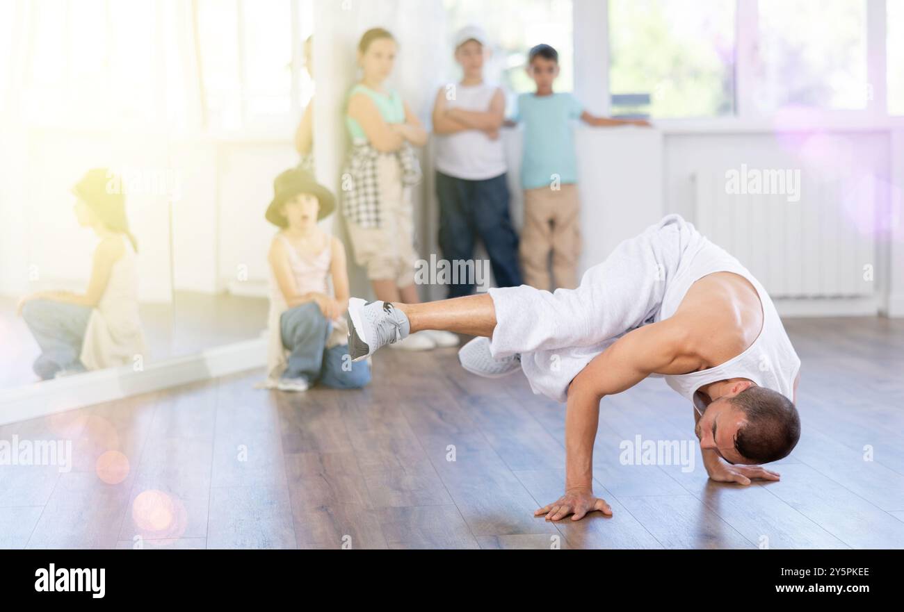 Dance teacher showing kids how to low break dance in studio Stock Photo ...