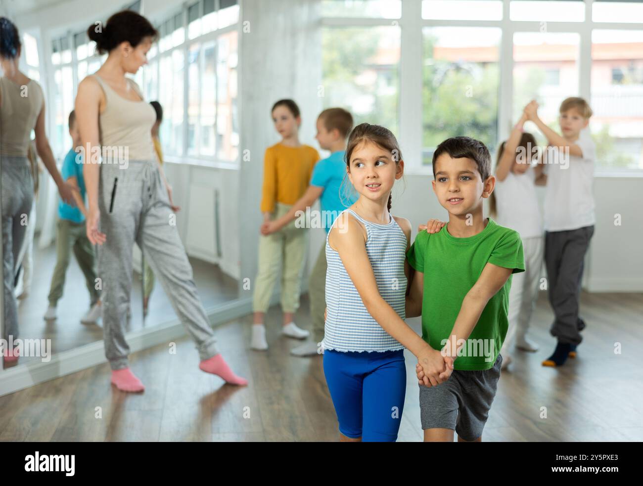 Happy preteen children practicing ballroom dances in pairs in training ...