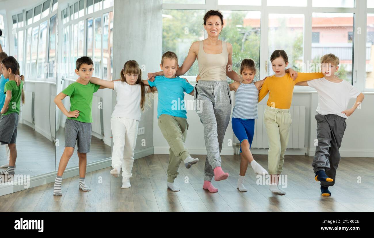 Group of children stand in row holding hands, performing Irish folk ...
