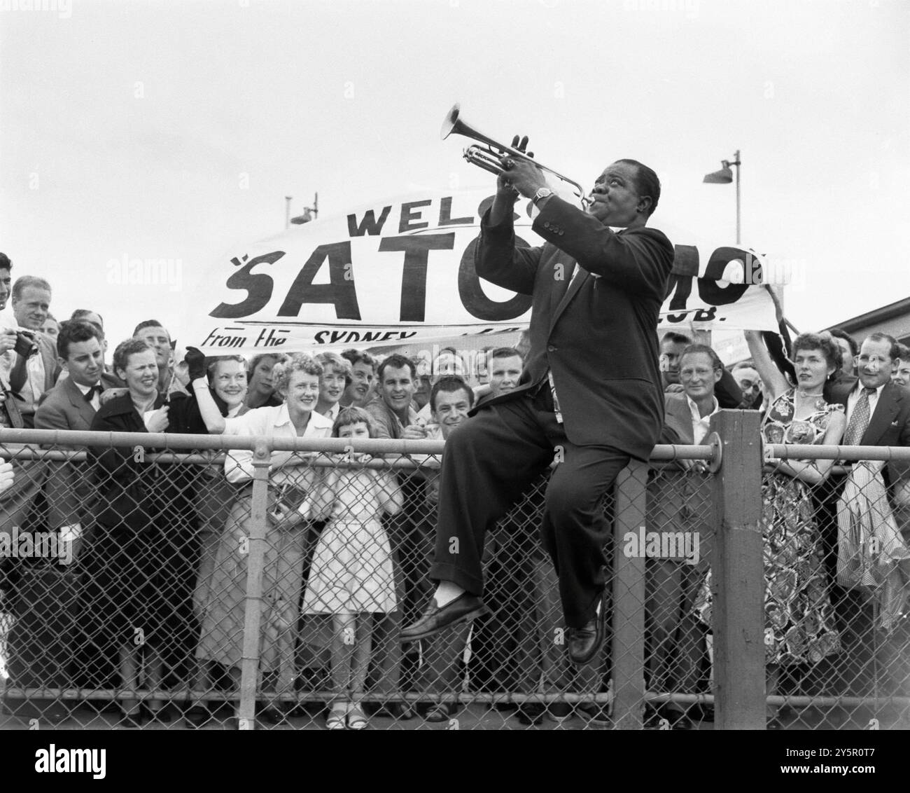 Jazz Legend Louis "Satchmo" Armstrong plays trumpet for fans on arrival ...