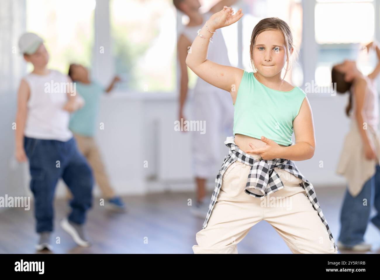 Tween girl dancer rehearsing krump dance at group workout Stock Photo ...