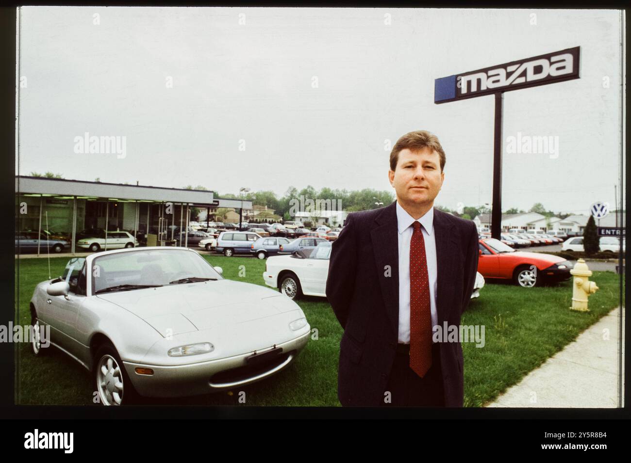 A salesman stands in front of a Mazda dealership in Trenton, New Jersey ...