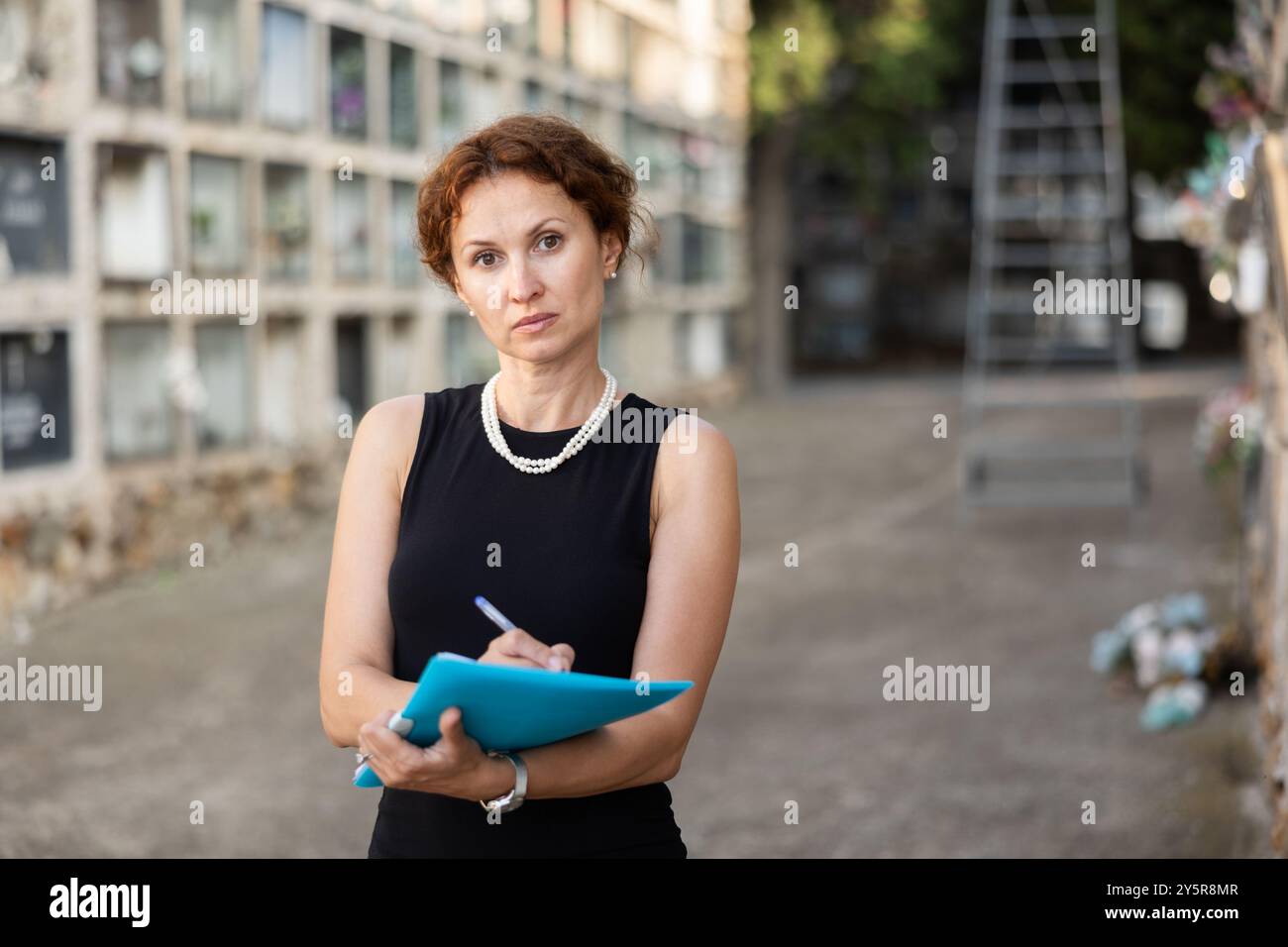Female funeral director filling out documents by columbarium Stock ...