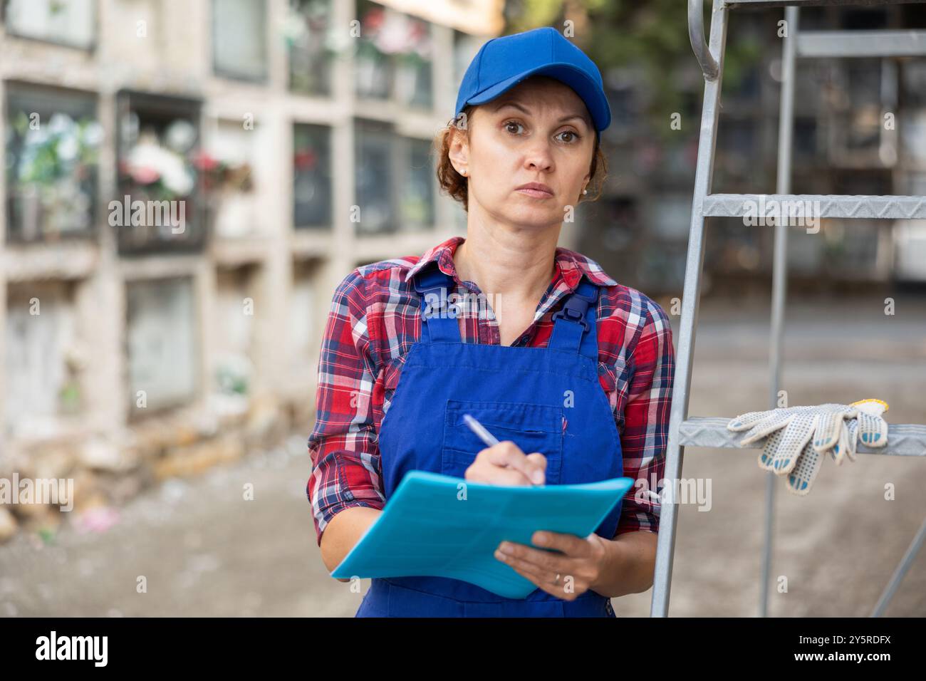 Female cemetery worker writing notes by columbarium Stock Photo - Alamy