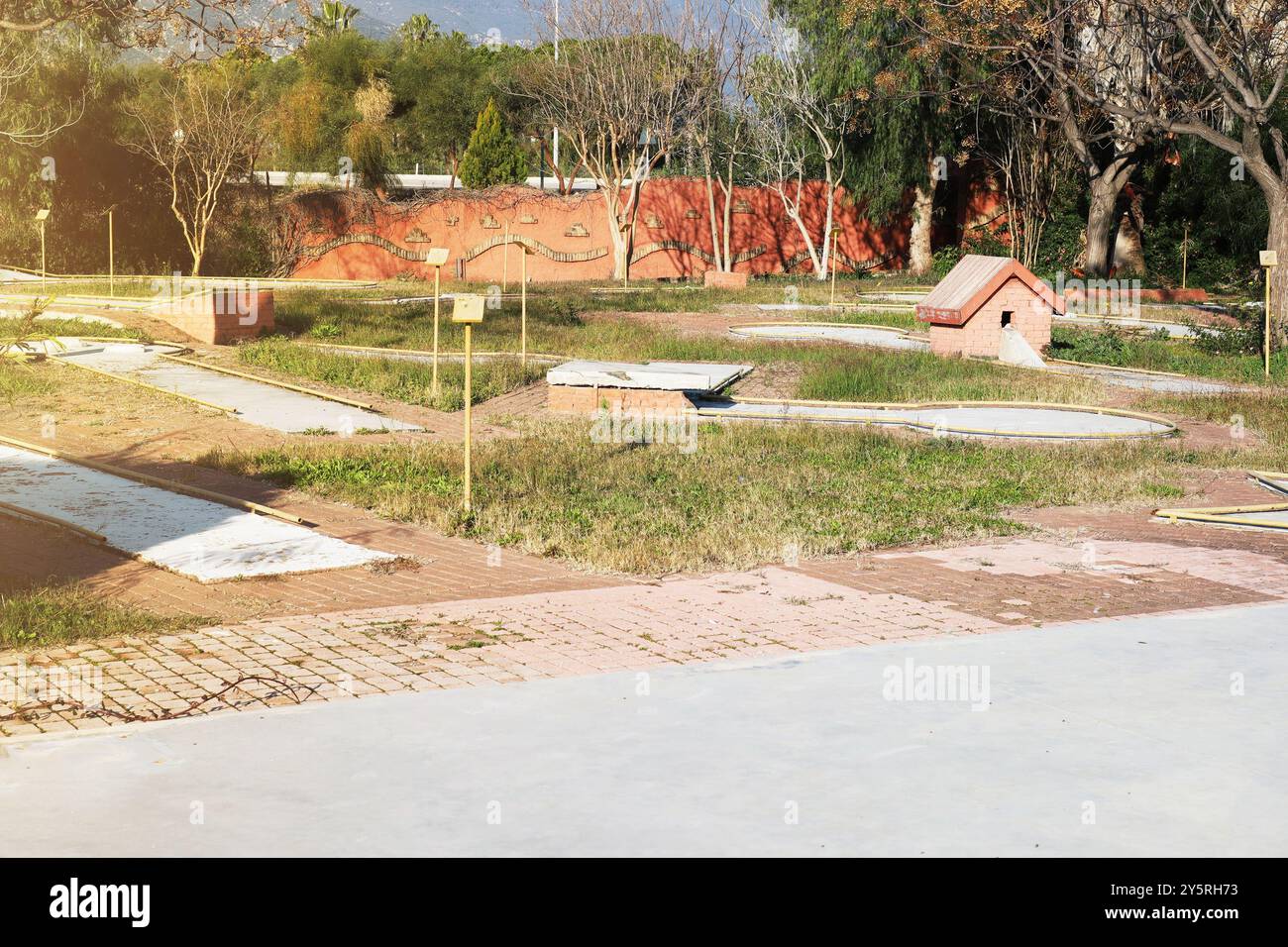 An abandoned mini golf course featuring overgrown grass, concrete ...