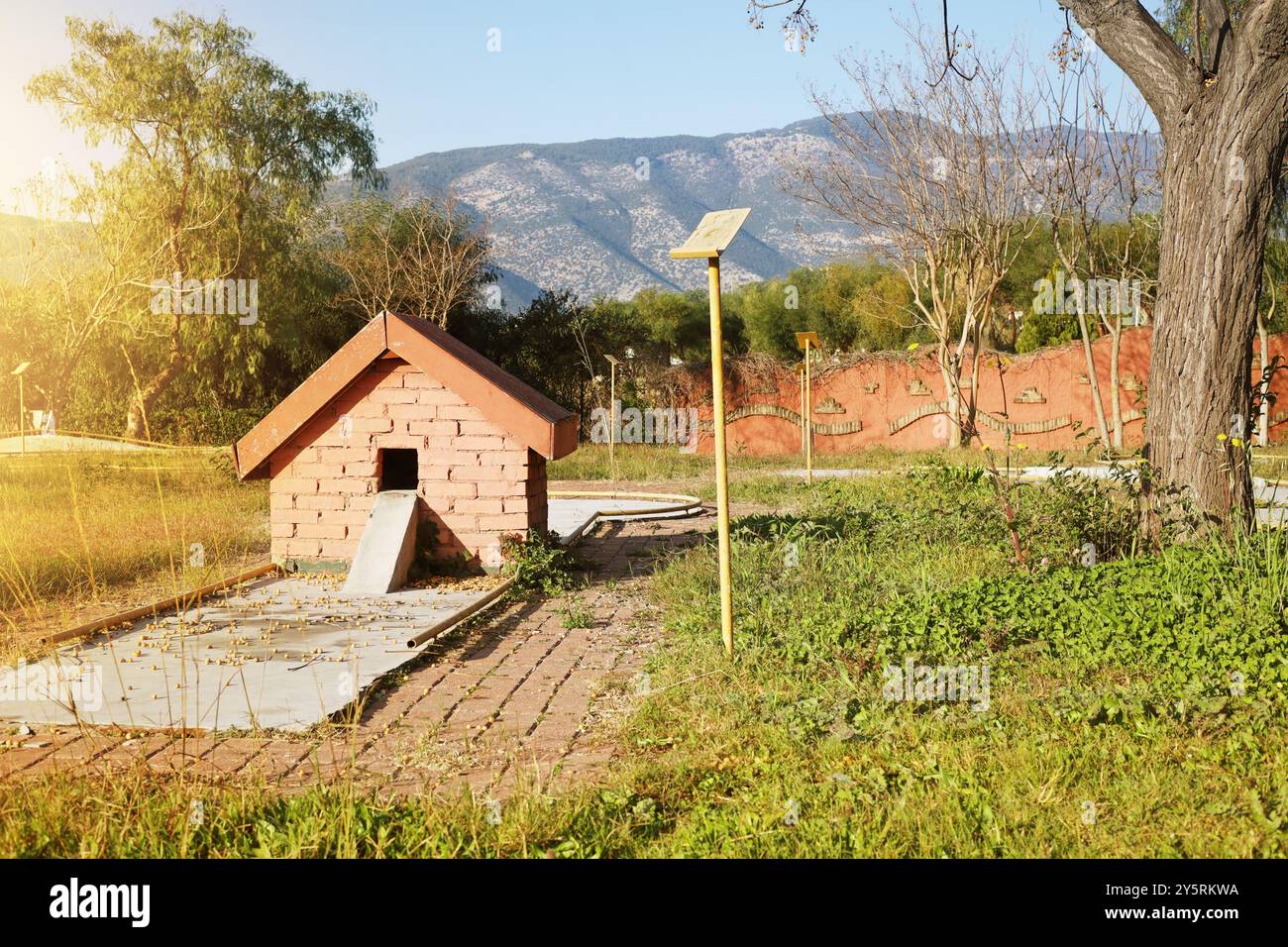 A small house-shaped obstacle is set along a path in a mini golf course ...