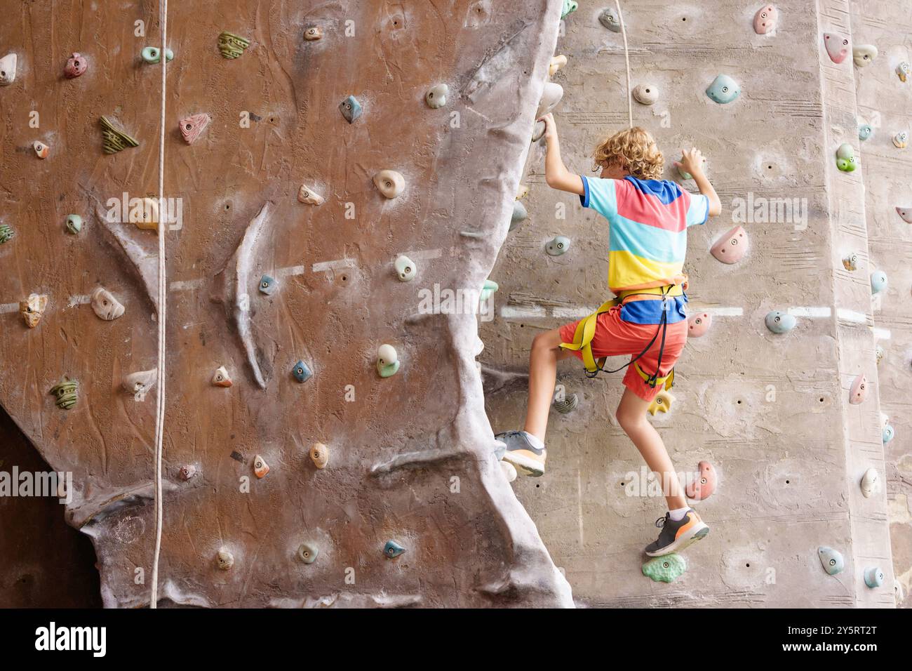 Child on rock climbing course. School boy bouldering. Extreme sport for ...