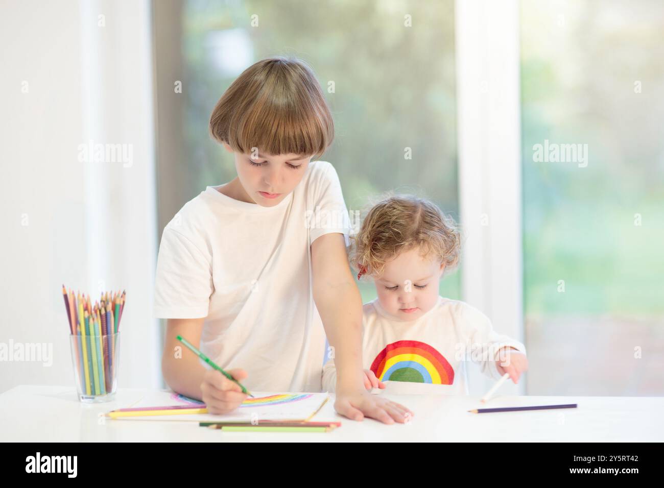 Kids paint. Child painting in white sunny study room. Little girl ...