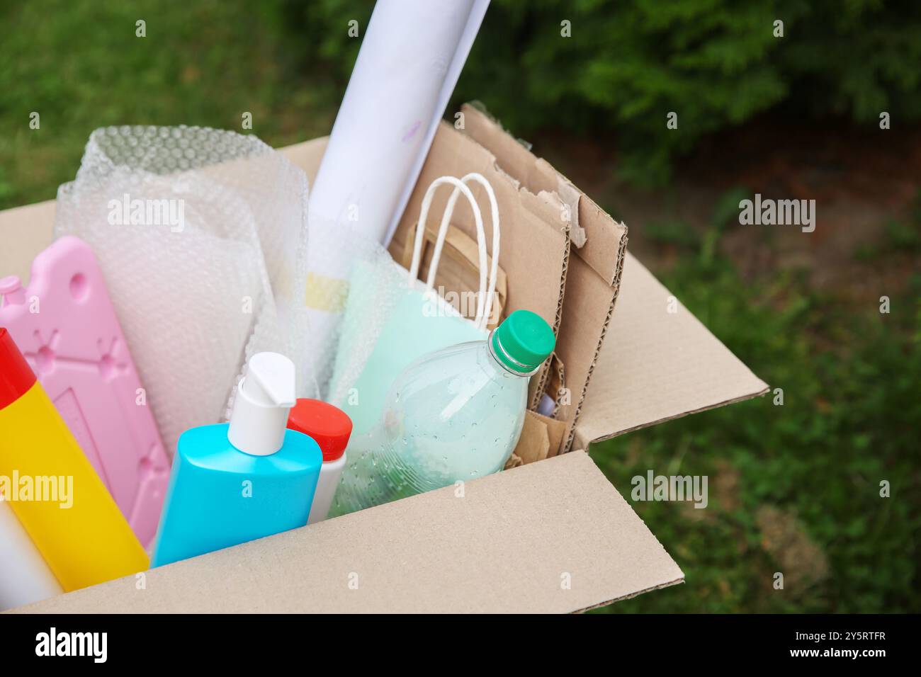 Recycling. Different garbage in cardboard box outdoors Stock Photo - Alamy
