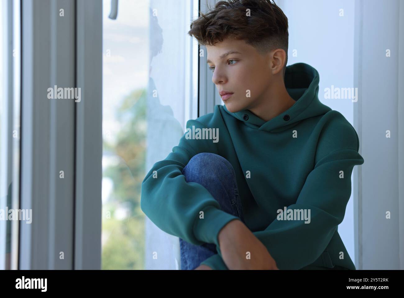 Loneliness concept. Sad teenage boy near window indoors Stock Photo - Alamy