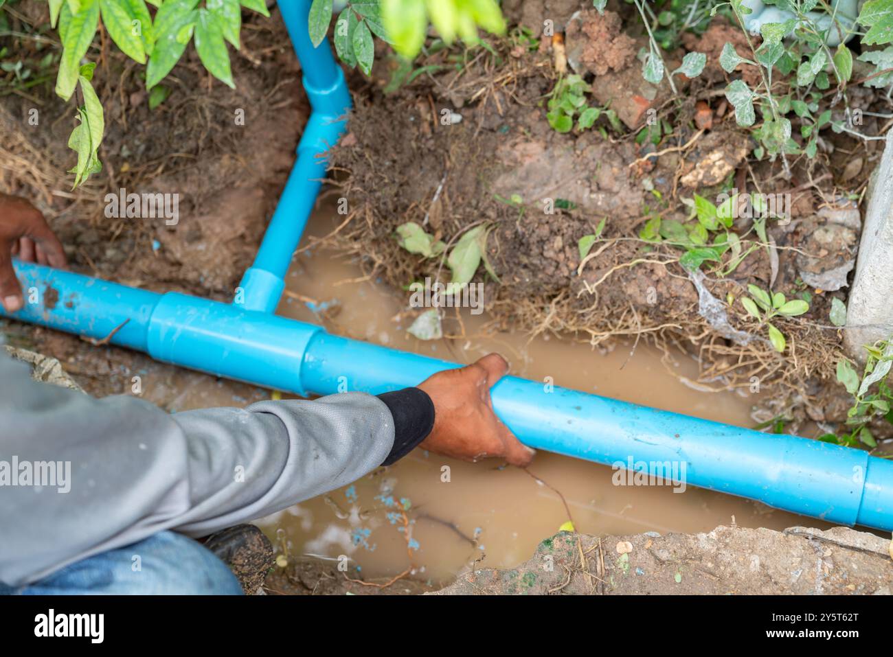Worker wear pvc pipe connect 3 way joint on ground Stock Photo - Alamy