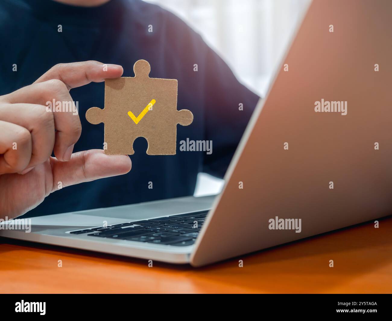 Yellow checkmark icon on jigsaw puzzle piece holding by businessman's ...