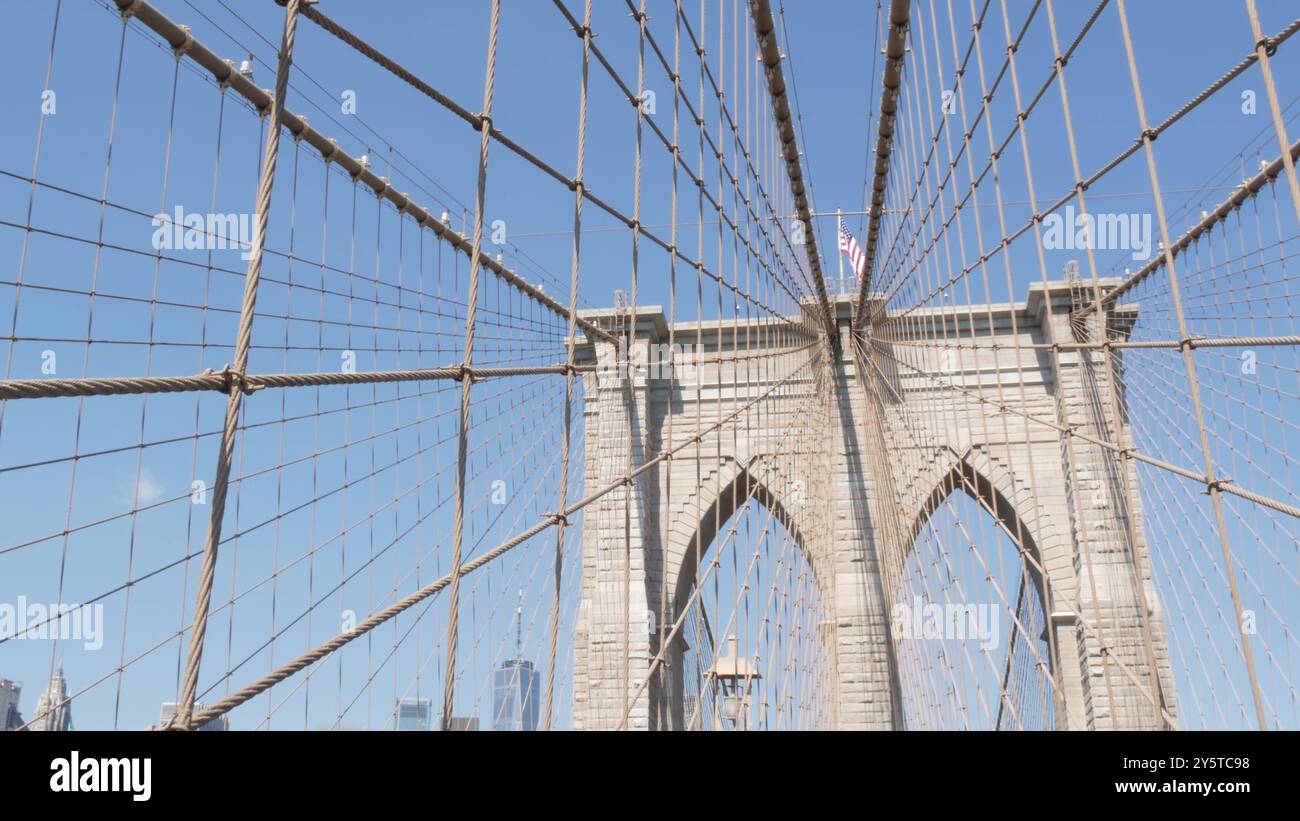 Brooklyn Bridge to Manhattan downtown, cables and blue sky. New York ...