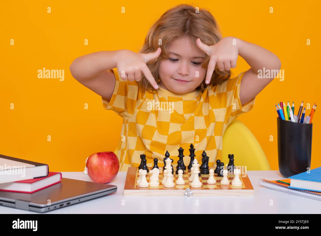 Child play chess on studio background. Child think about chess game ...