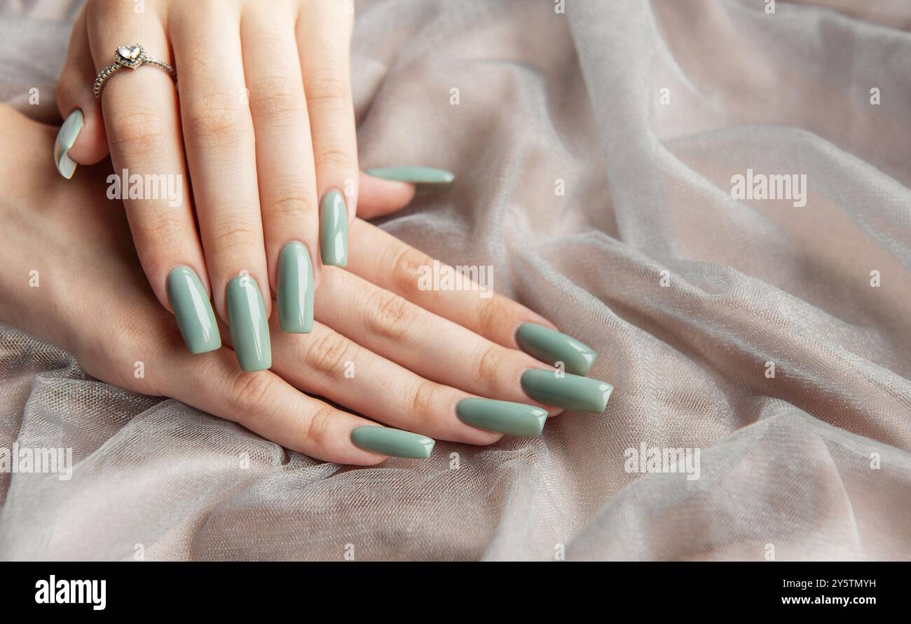 Soft fabric serves as a backdrop for elegantly manicured hands ...