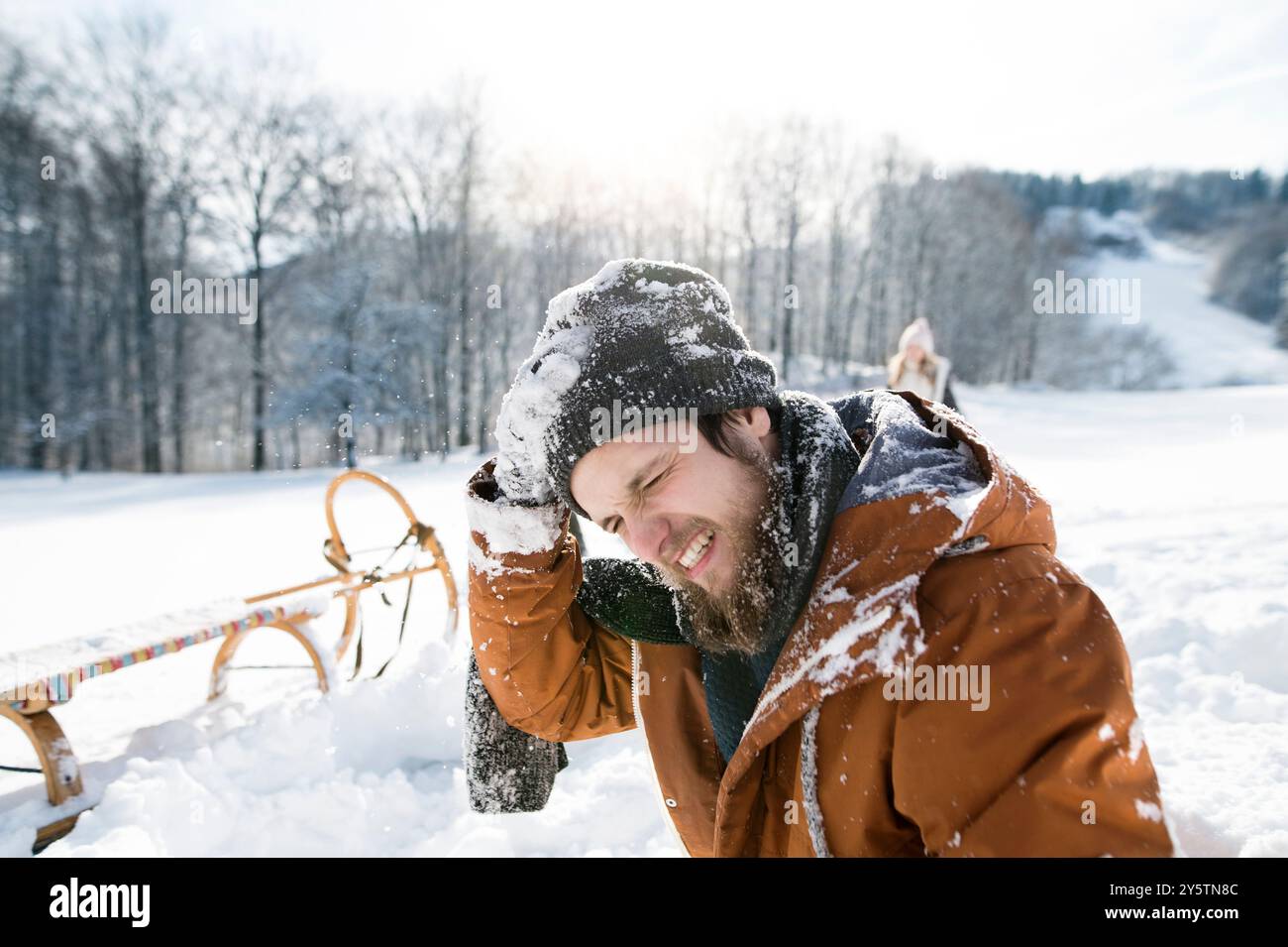 Portrait of man with head injury after snowball fight. Man sitting on ...