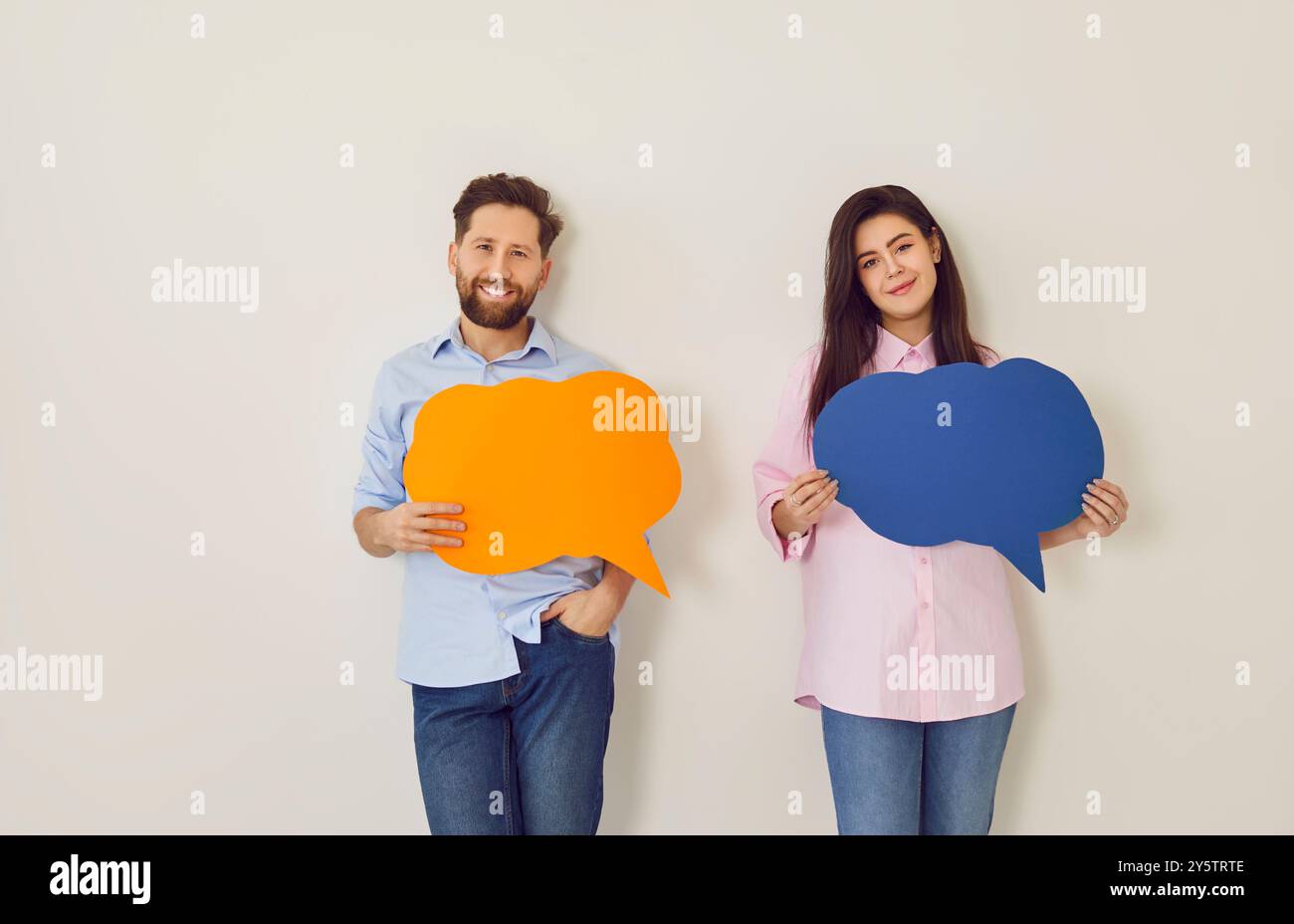 Man and woman hold large colorful speech bubbles that symbolize ...